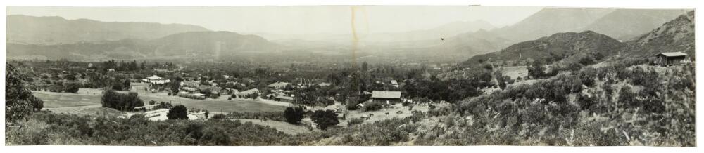 Panorama photograph with wooded hills and scattered buildings